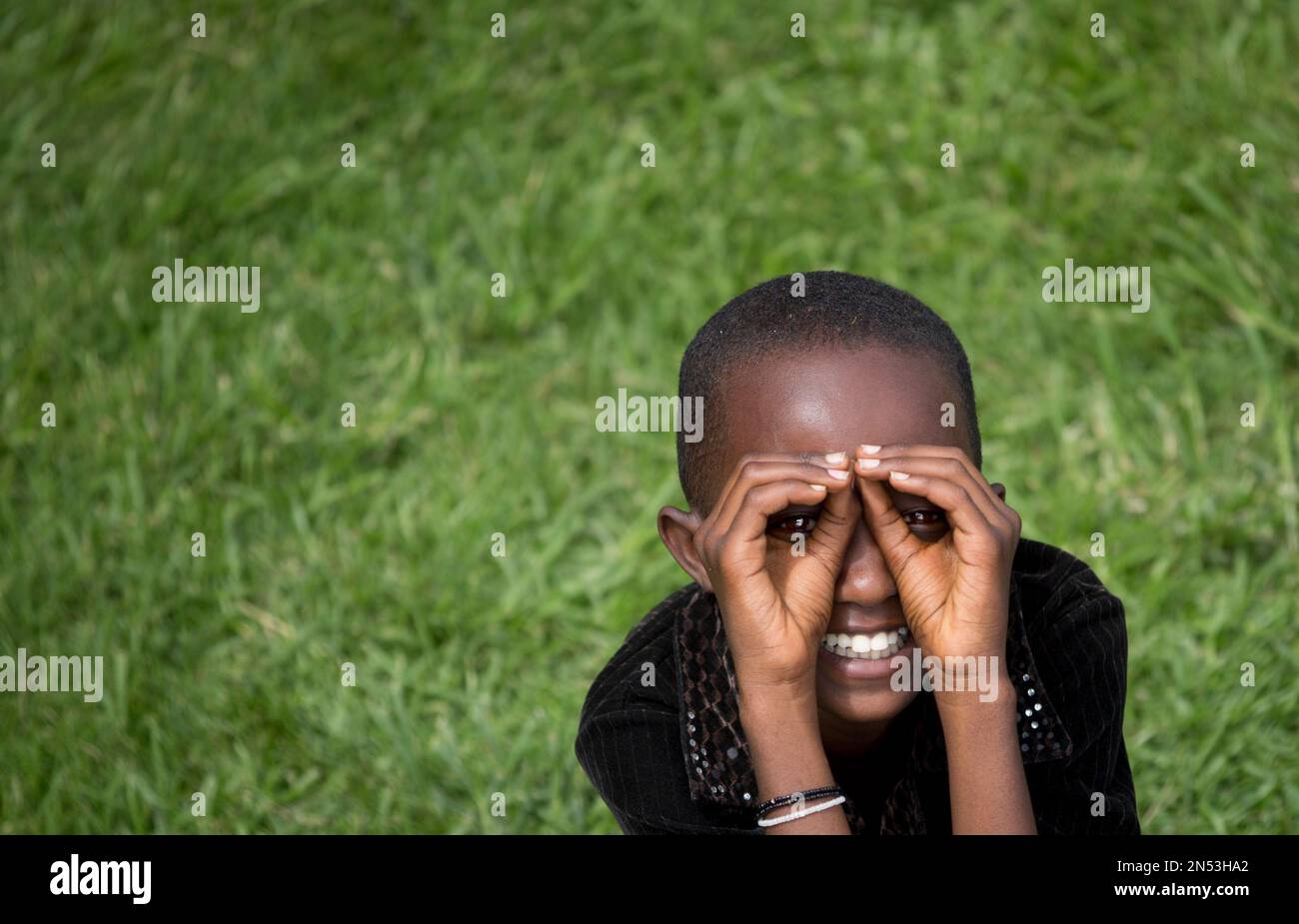A young Rwandan girl mimics the photographer taking her photograph, at ...