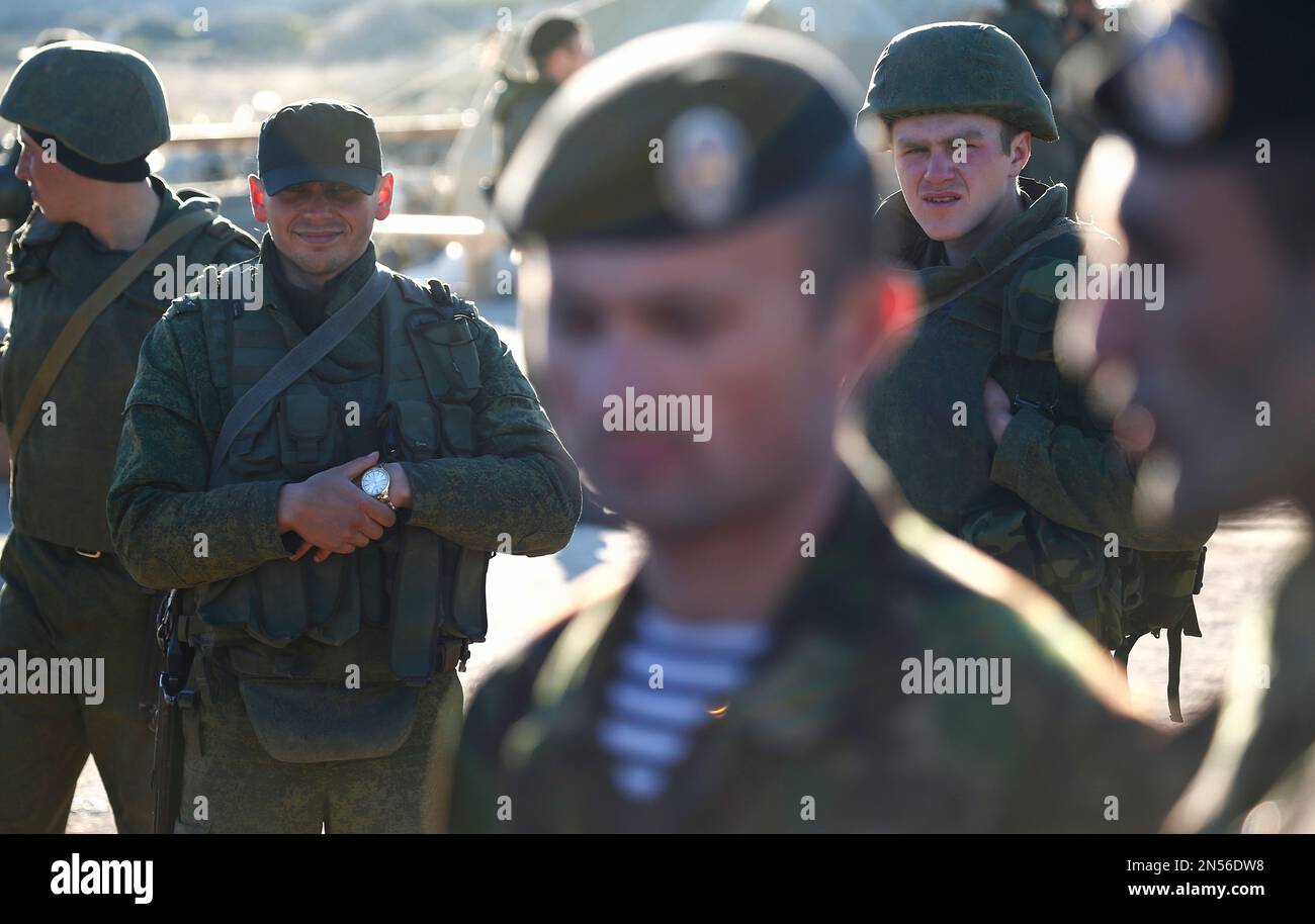 Pro-Russian soldiers in unmarked uniforms look on from behind as Ukrainian marines officers ...