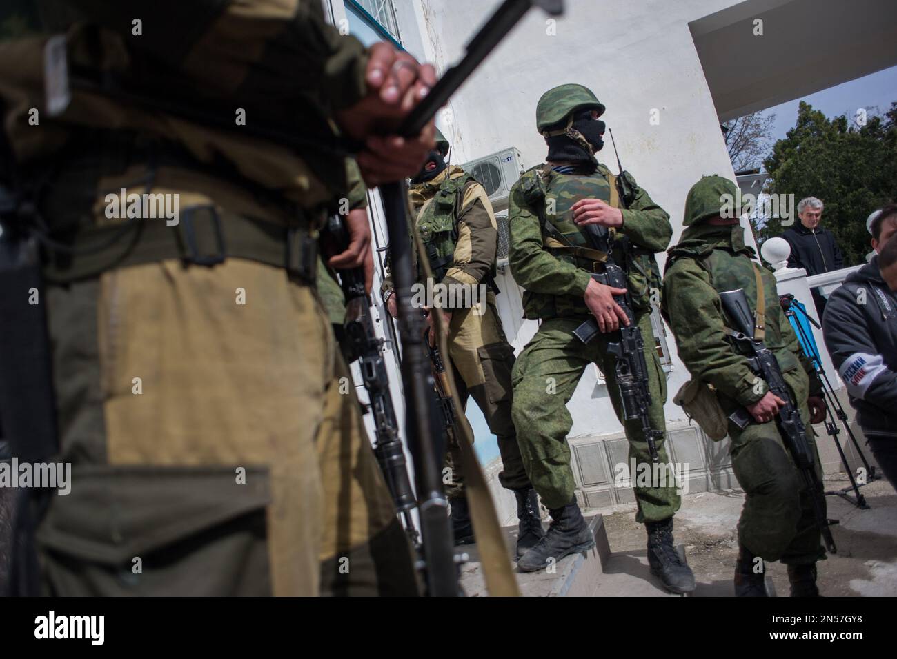 Soldiers in unmarked uniforms stand guard the entrance to the Ukrainian ...