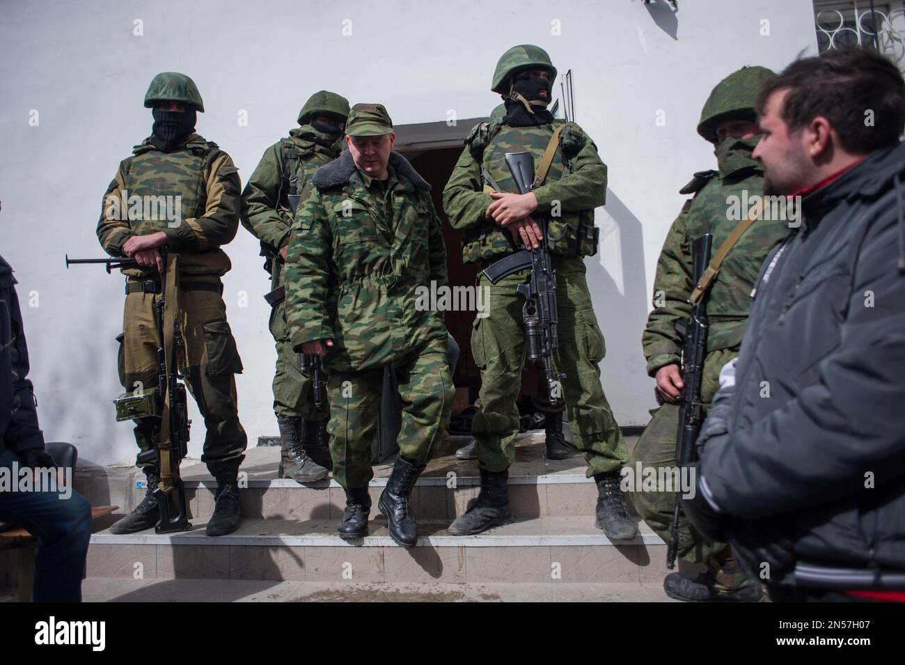 Soldiers in unmarked uniforms stand guard at the entrance to the Ukrainian navy headquarters ...