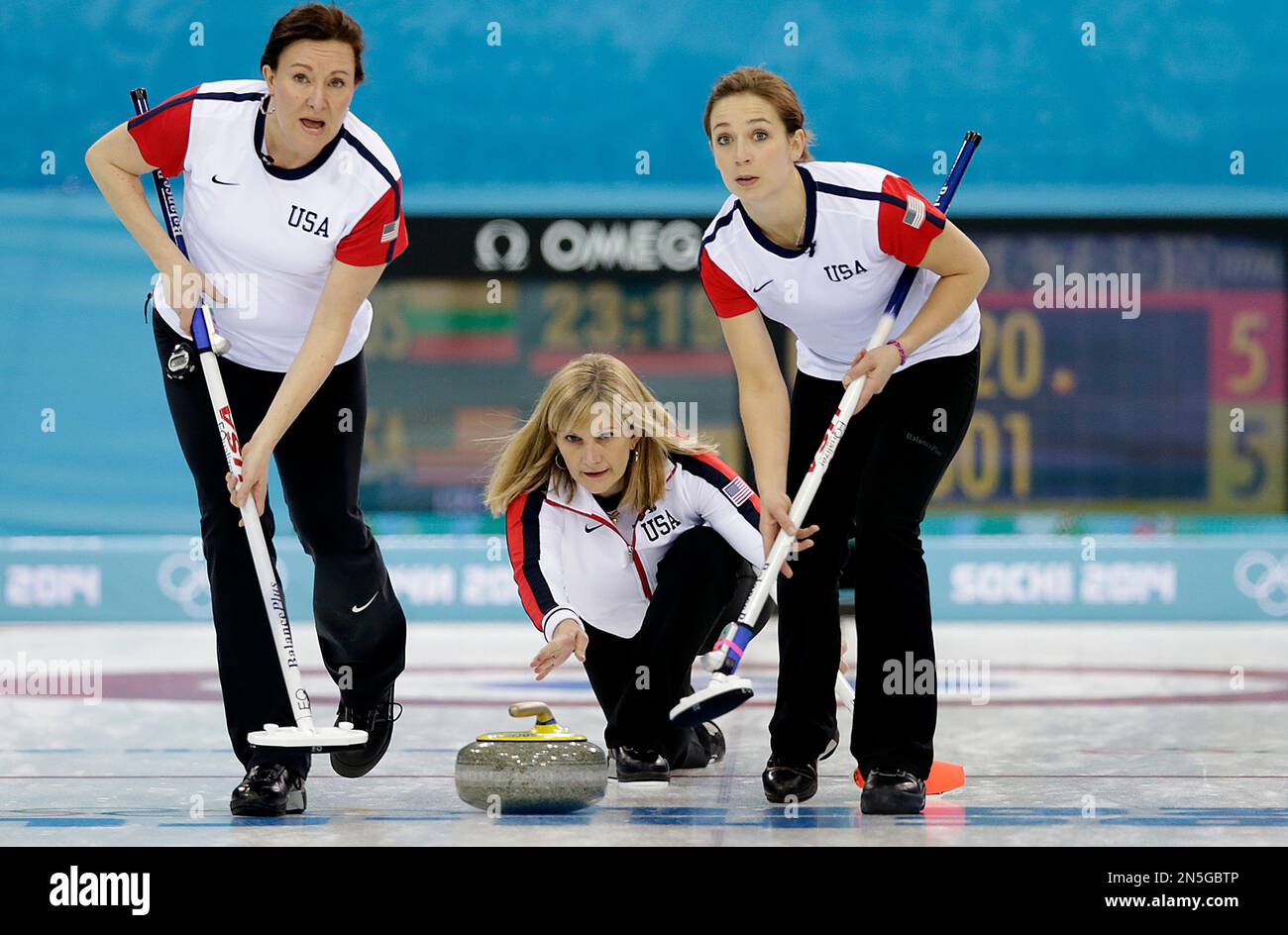 Erika Brown, center, skip for the United States delivers the rock while ...