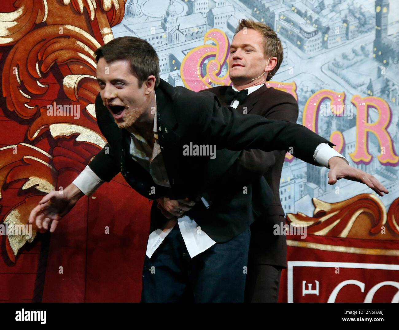 Actor Neil Patrick Harris, right, gives the Heimlich maneuver to actor ...