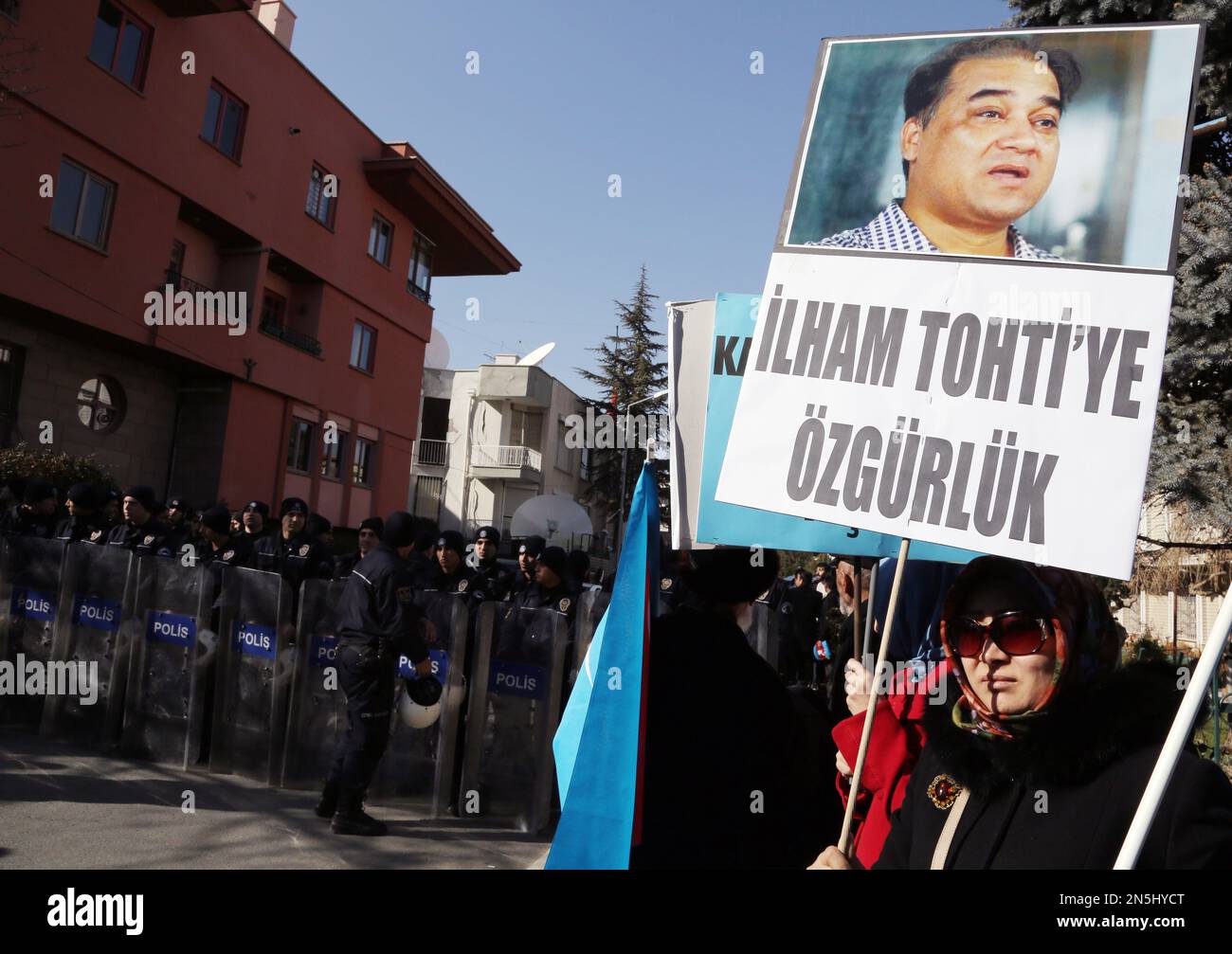 An Uighur woman living in Turkey holds a placard with a photo of Ilham ...