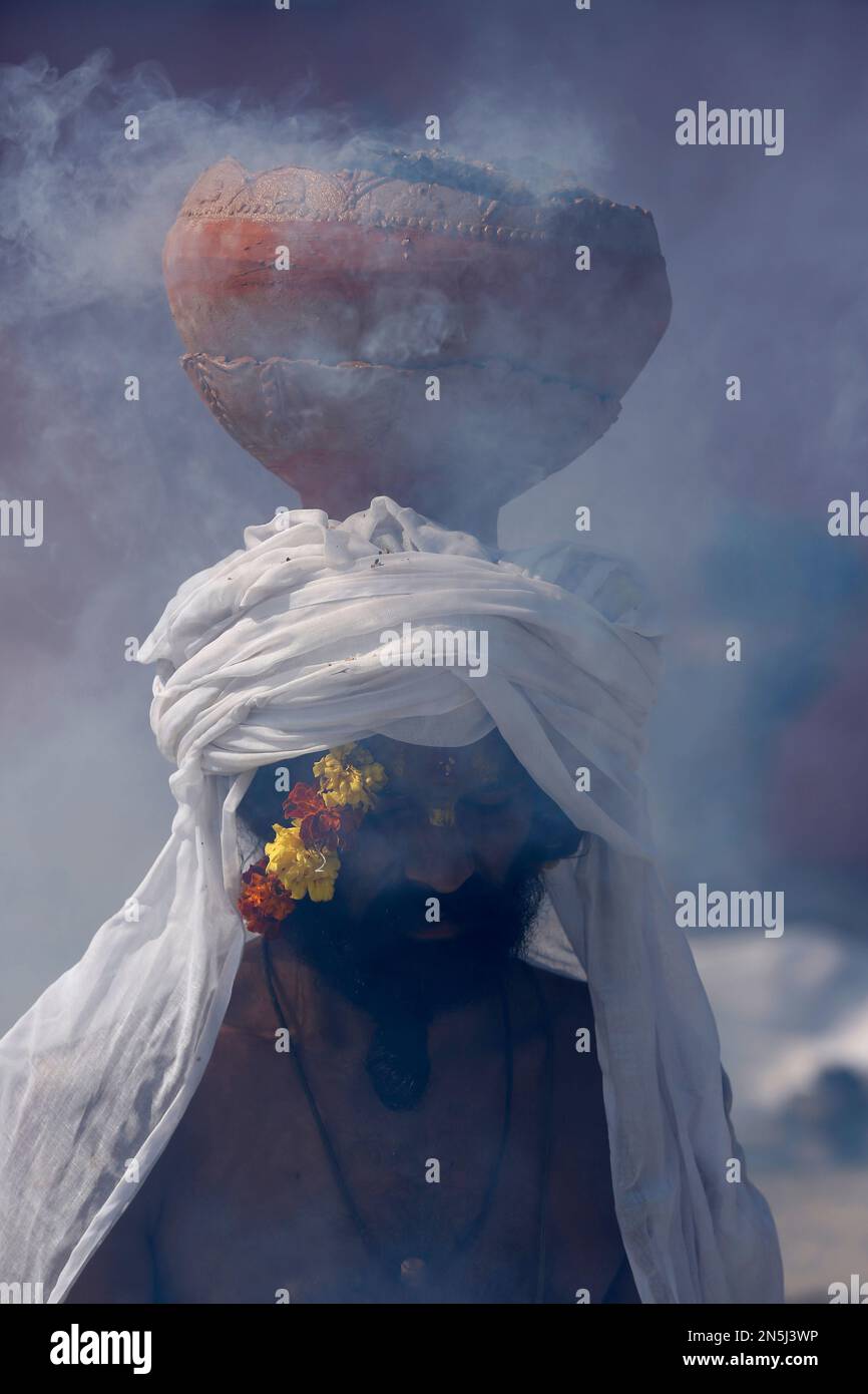 A Sadhu, or Hindu holy man performs a ritual by burning dried cow dung ...