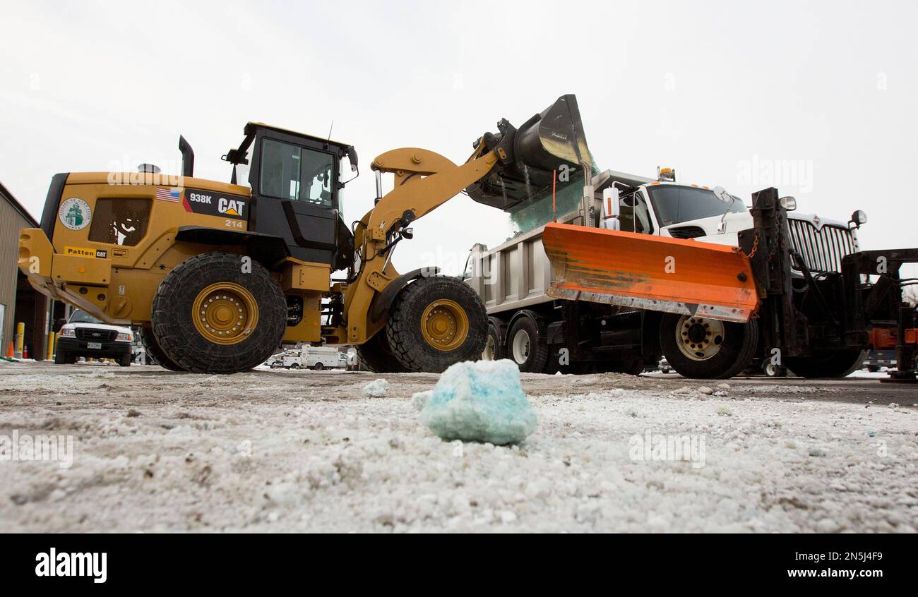 Road salt is loaded into a snow plow truck equipped with a salt ...