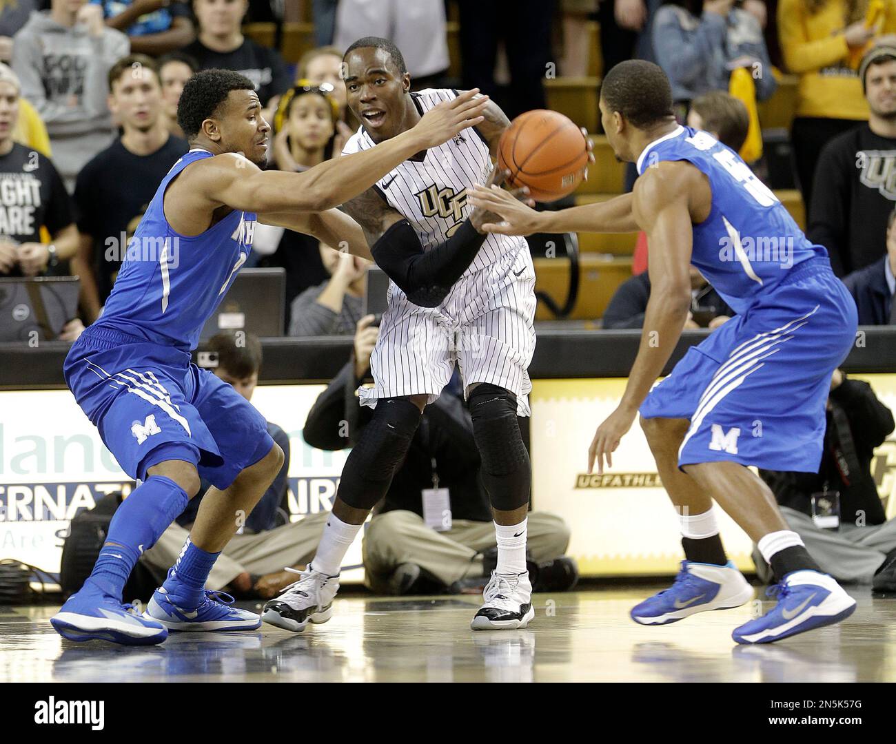 Central Florida's Isaiah Sykes, center. looks to pass the ball as he is ...