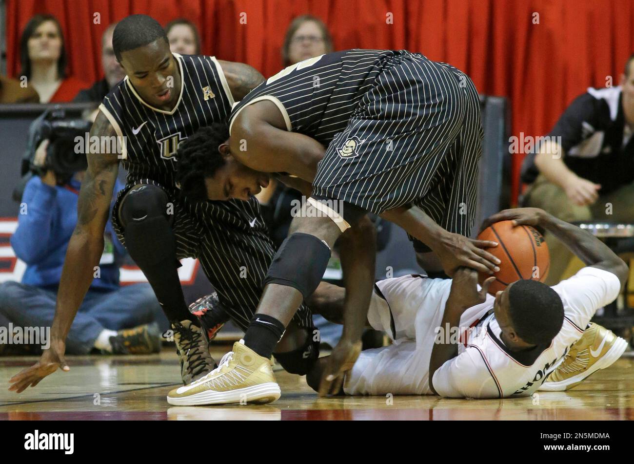 Central Florida forward Staphon Blair, center, reaches for a loose ball ...