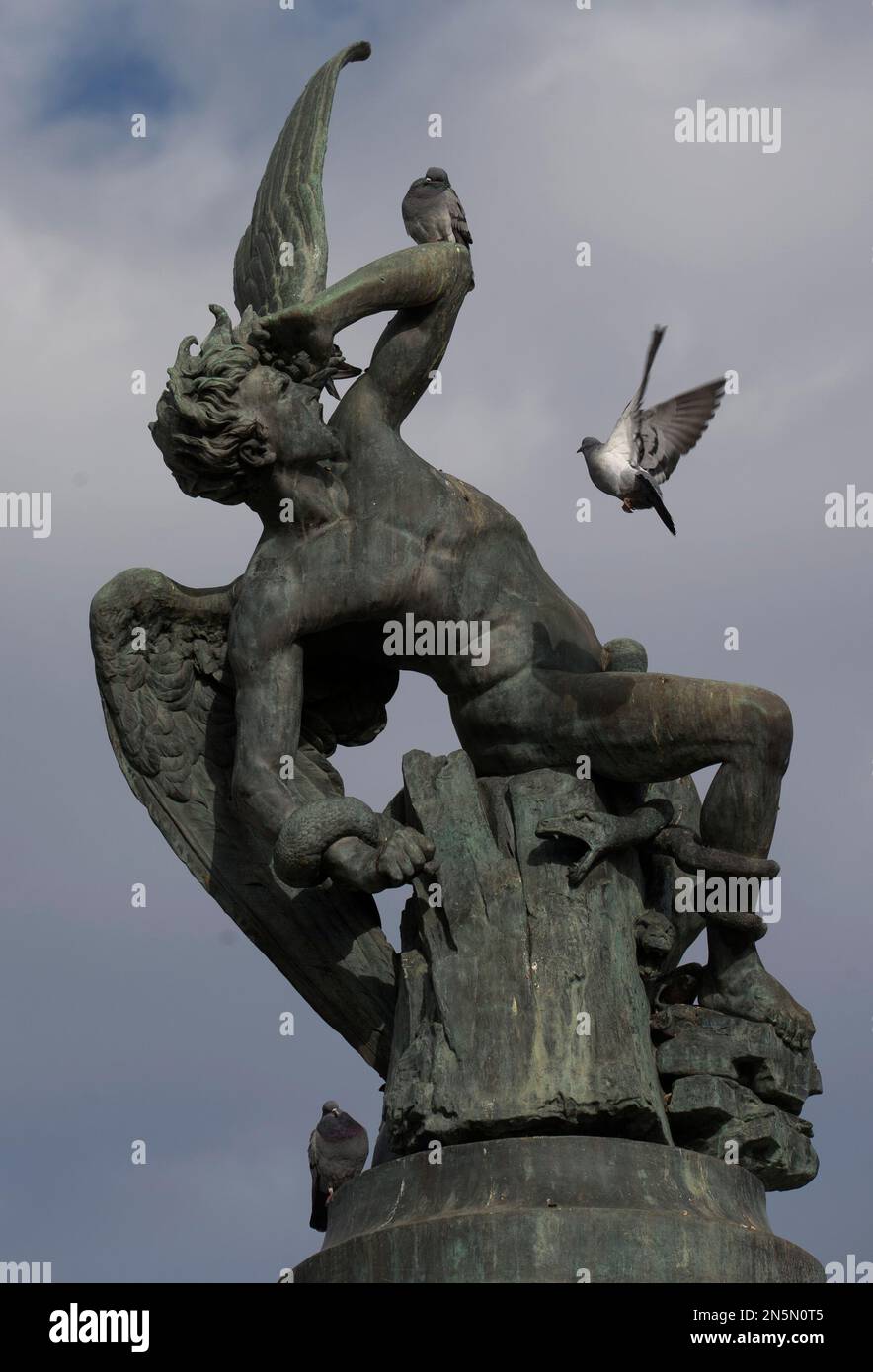 A pigeon sits on the statue of Lucifer as another prepares to land in ...