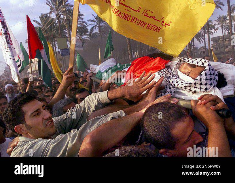 Mourners try to touch the face of 16-year-old Omar Al-Bahassi as his ...