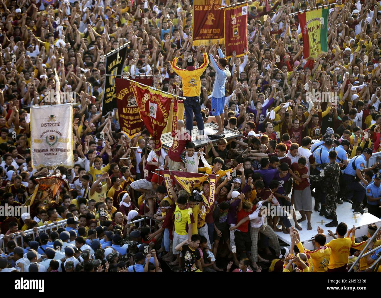 Filipino Catholic devotees raise their hands to pray during a mass at ...