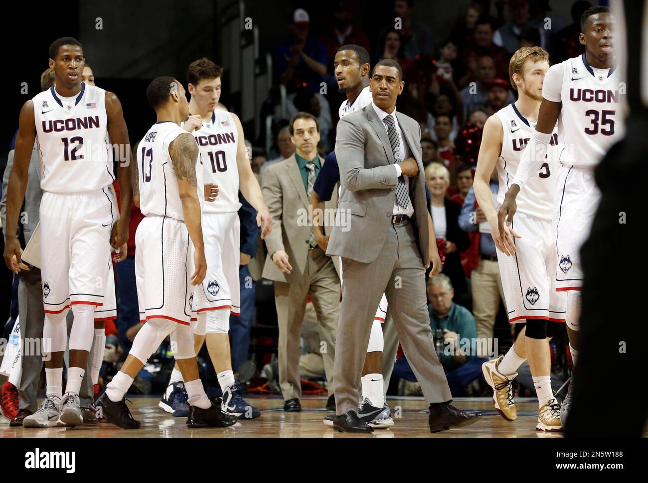 Connecticut head coach Kevin Ollie and the rest of the team look ...