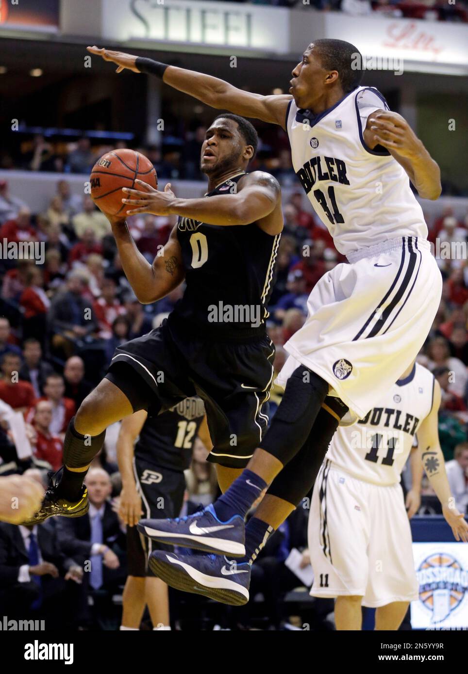 Purdue guard Terone Johnson, left, goes under Butler forward Kameron ...
