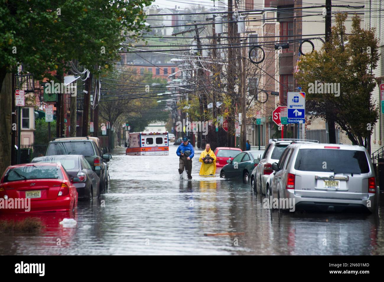 In this Oct. 30, 2012 photo, residents walk through flood water and ...