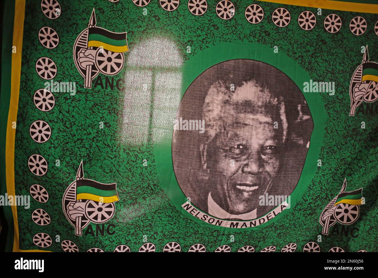 People hold a cloth with the face of former South African president ...