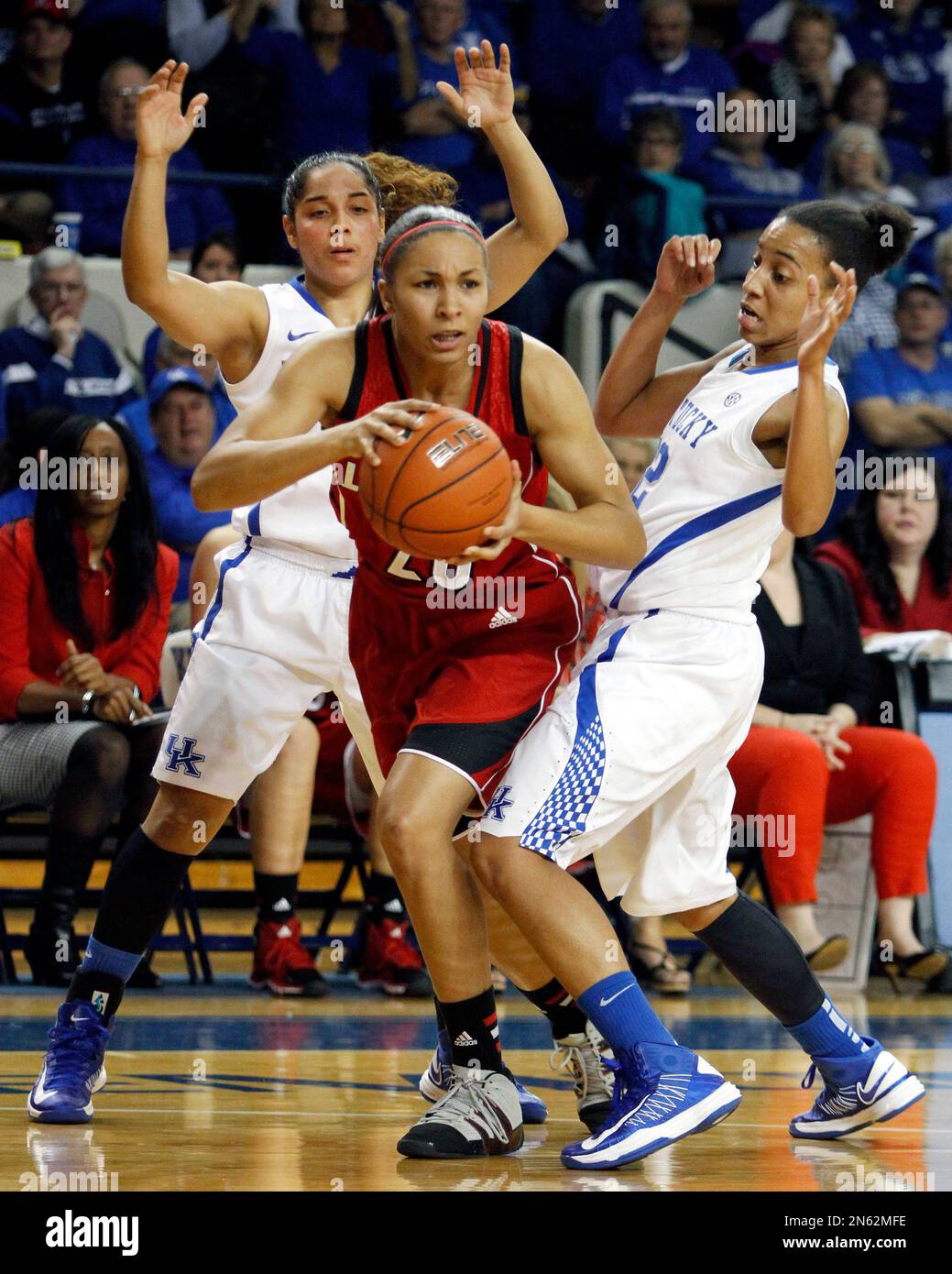 Louisville's Tia Gibbs, center, looks for an opening between Kentucky's ...