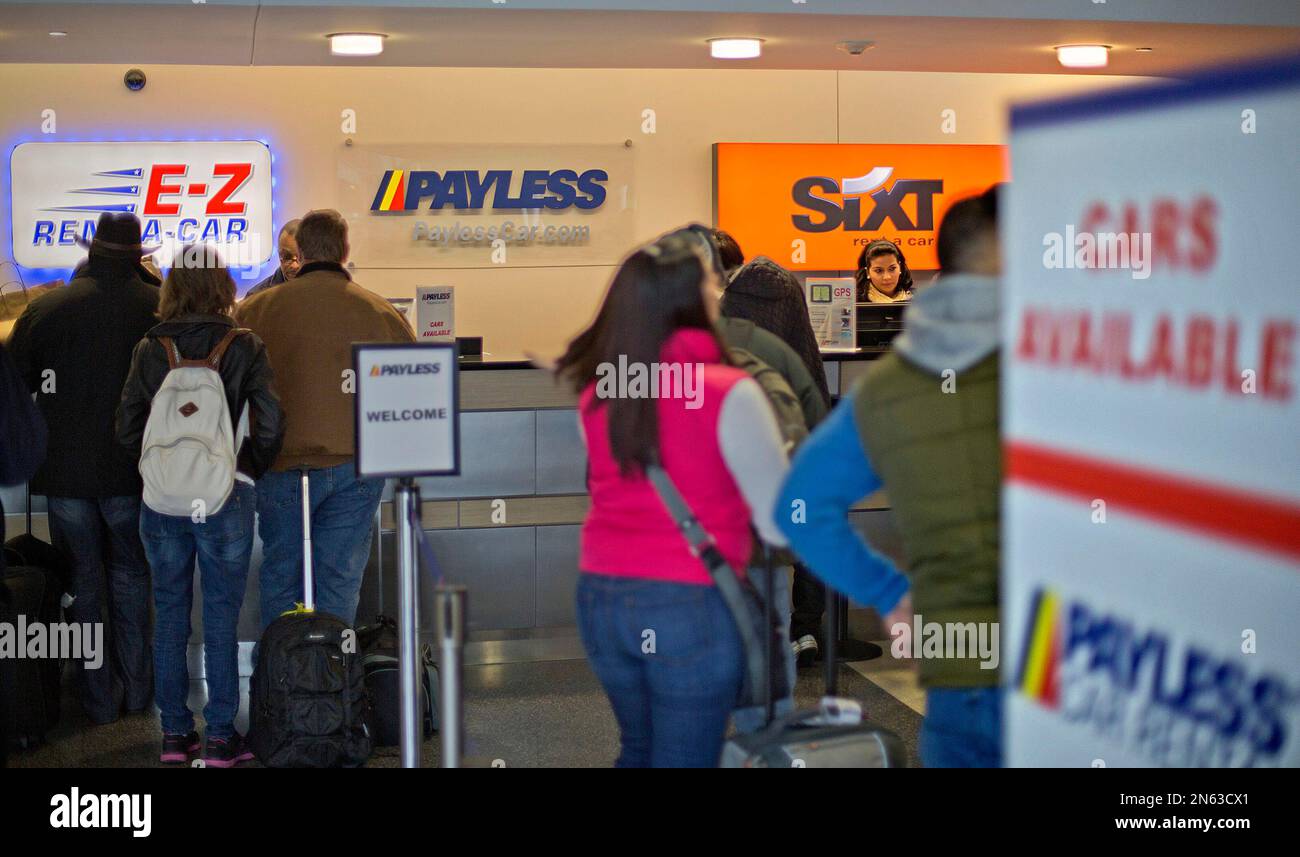 Customers wait in line at the check-in counters of the car rental ...