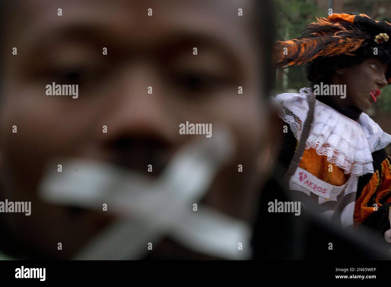 A demonstrator, foreground, turns his back to the parade of Sinterklaas ...