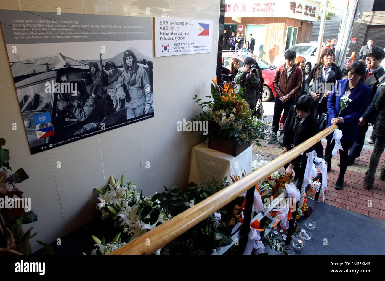 College students place flowers for victims of Typhoon Haiyan in the ...