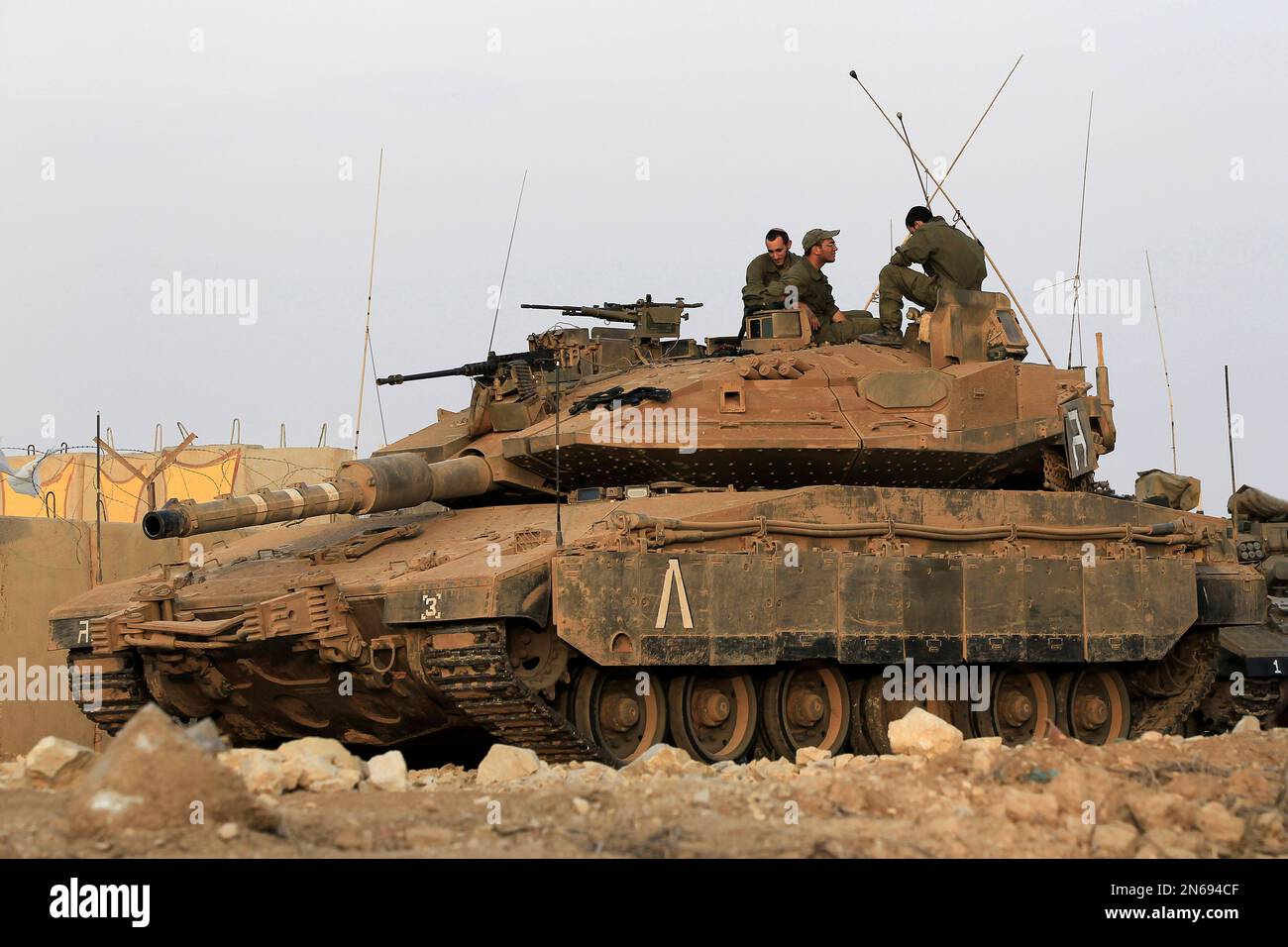 Israeli soldiers sit on top of a tank near the border between Israel ...
