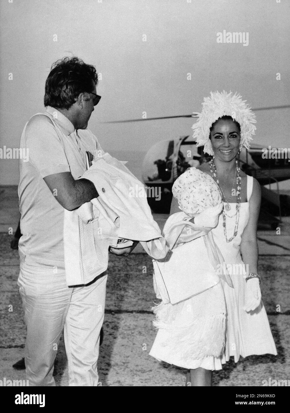 Suntanned and smiling, British-born actress Elizabeth Taylor walks from ...