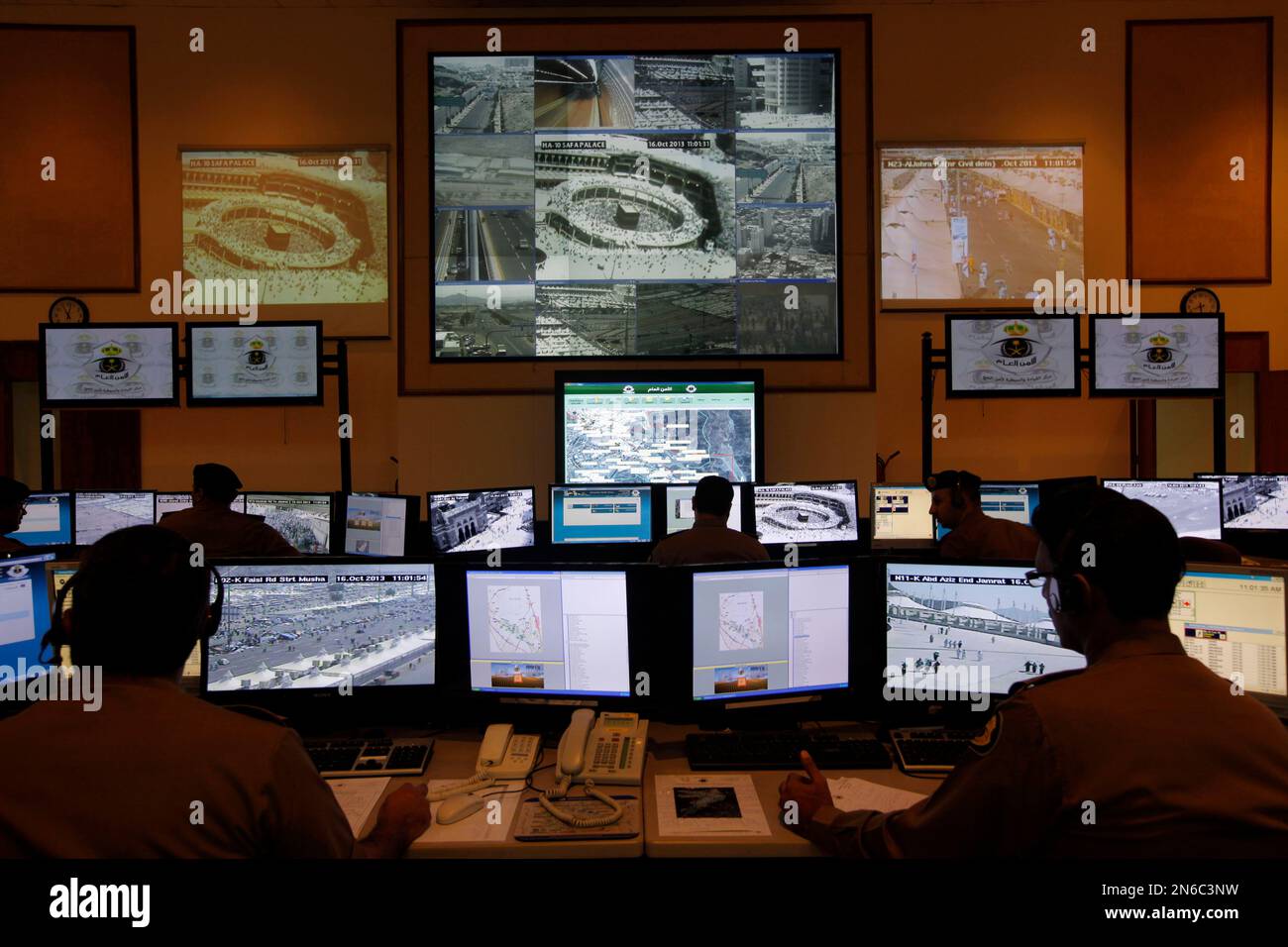 Saudi police officers monitor screens connected to cameras to monitor ...