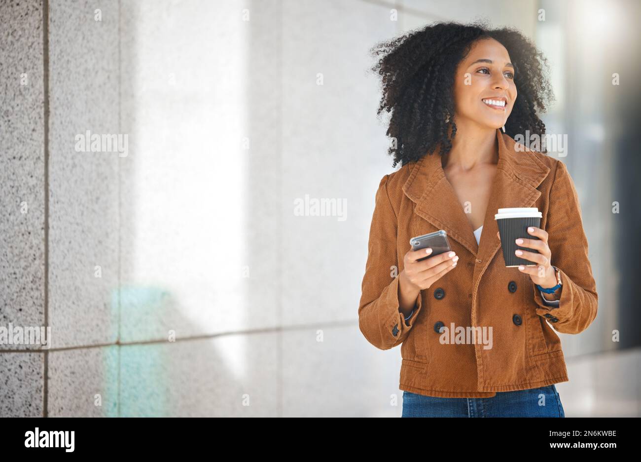 Eine schwarze Frau, die mit Kaffee, Telefon in der Stadt spaziert und ... Eine schwarze Frau, die mit Kaffee, Telefon in der Stadt spaziert und ...