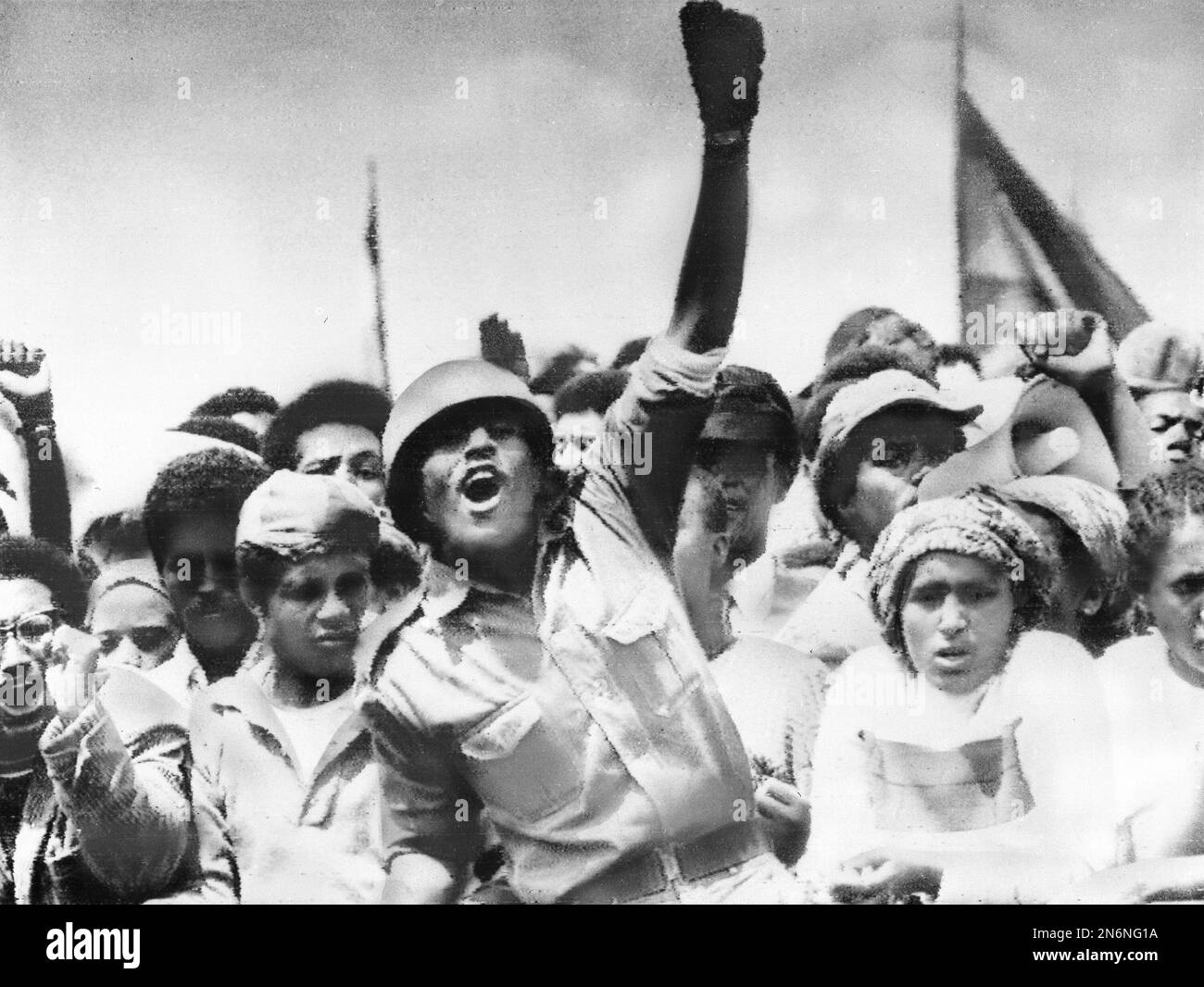 Fist clenched in a revolutionary salute, an Ethiopian soldier, center ...