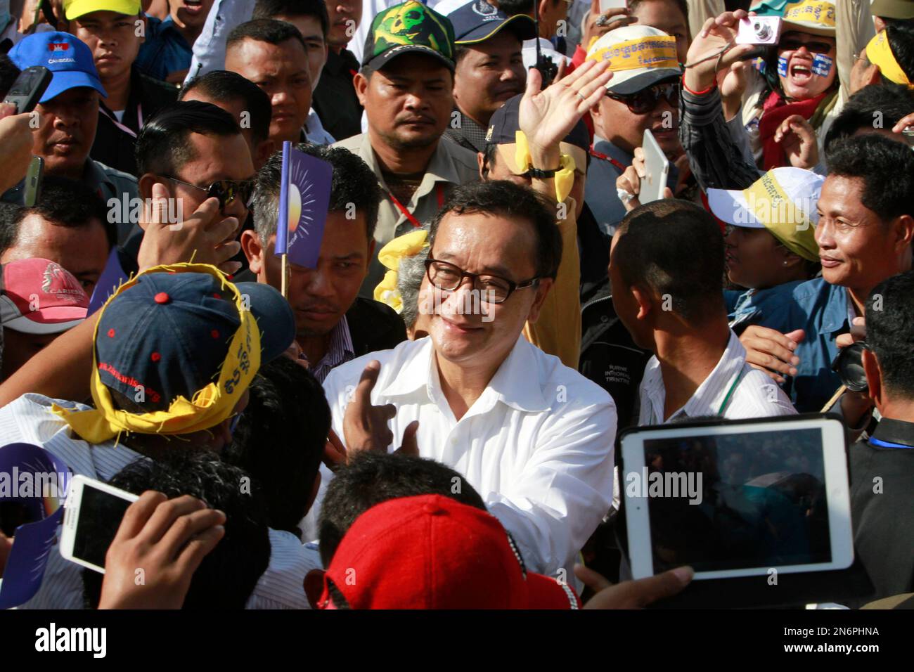 Cambodia's opposition leader Sam Rainsy, center, greets his supporters ...