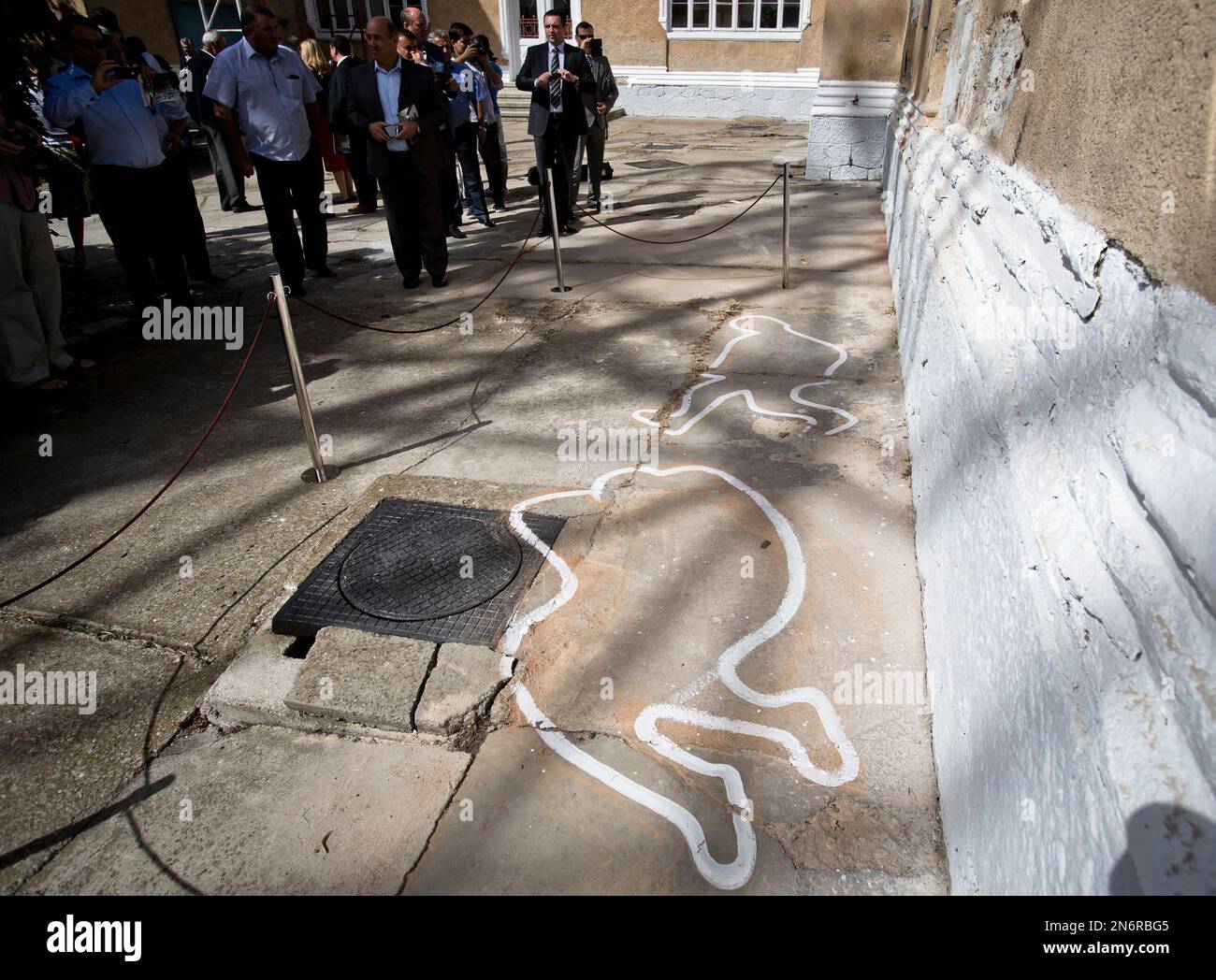 Visitors take pictures of the spot where Nicolae Ceausescu, foreground, and his wife Elena were ...