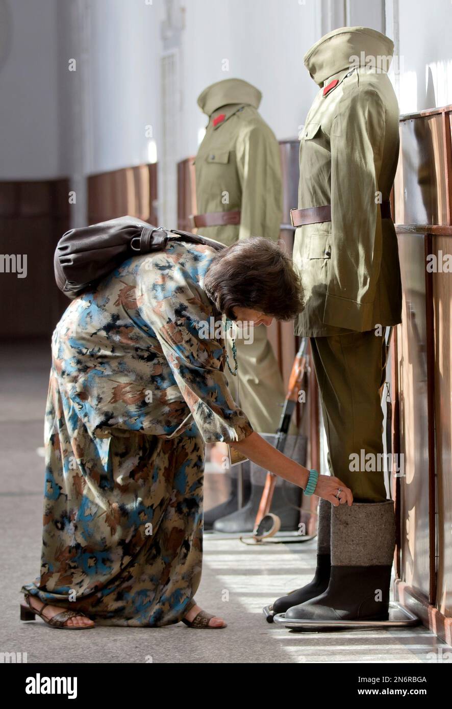 A woman working for the museum adjusts an exhibit uniform outside the ...