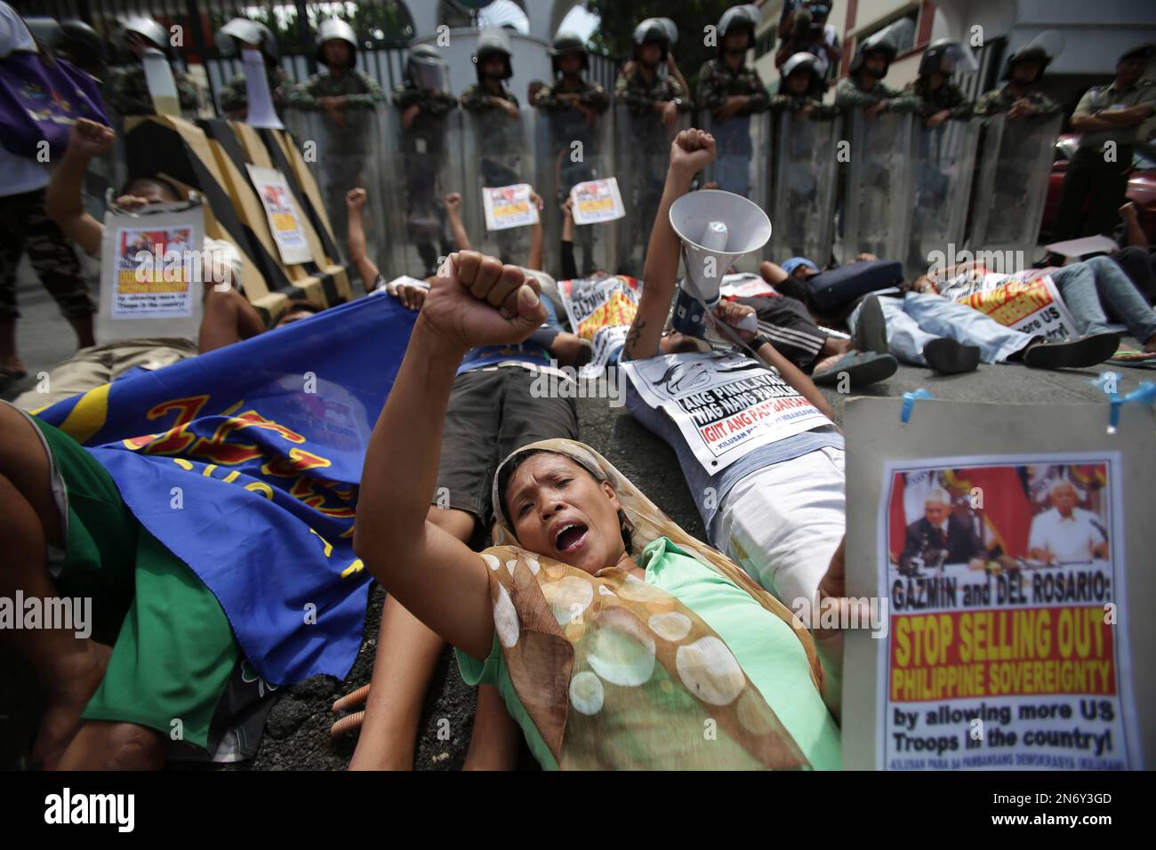 Filipino activists shout slogans as they lie on the street to protest a ...