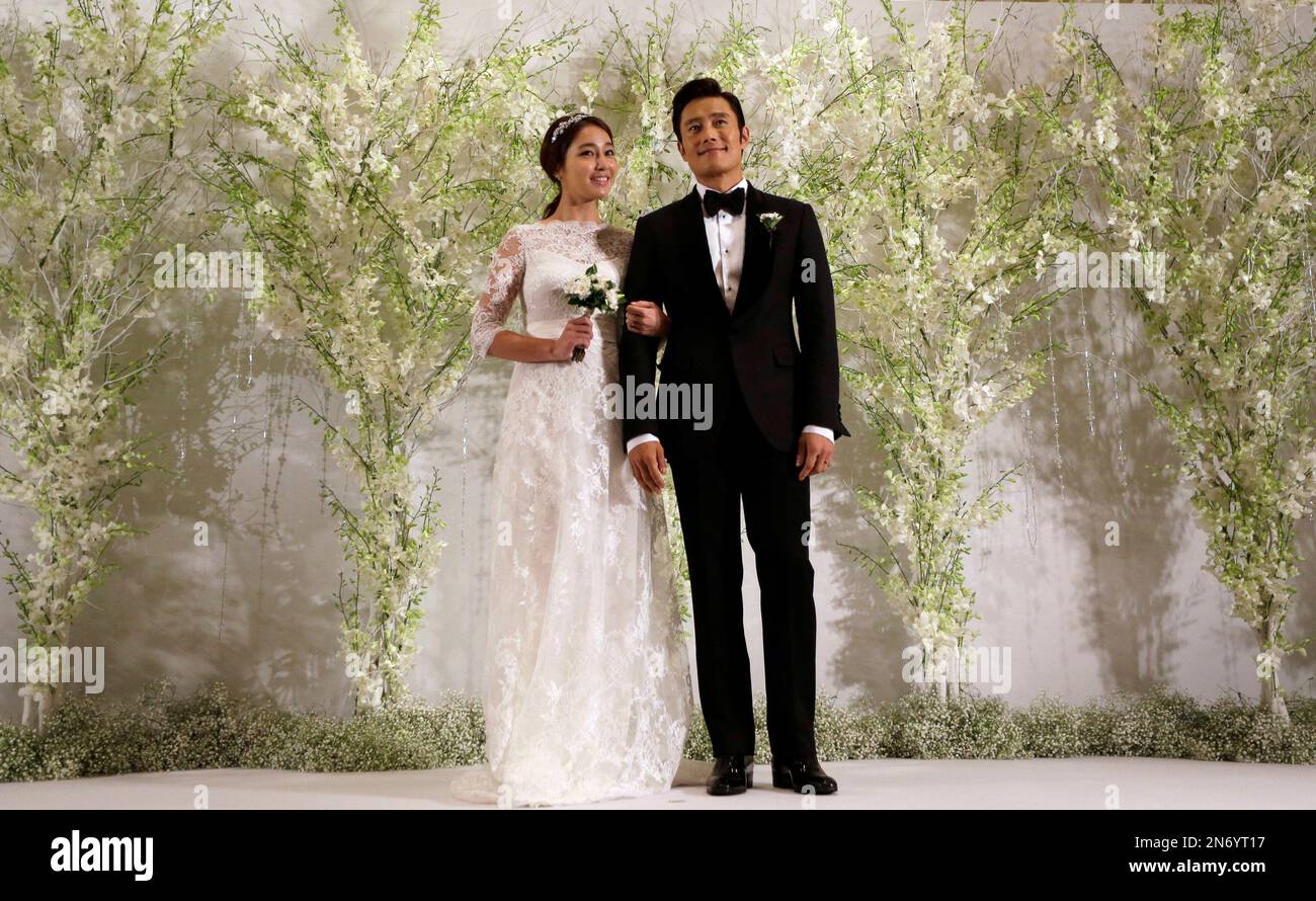 South Korean actor Lee Byung-hun poses with his bride and actress Rhee ...
