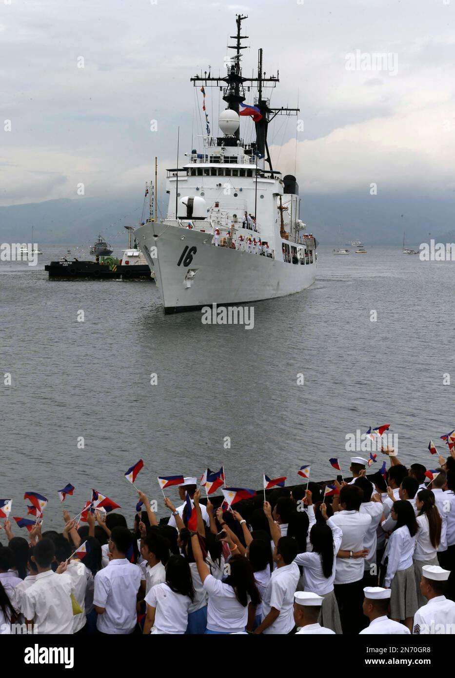 Students and other guests wave Philippine flags to welcome the second ...