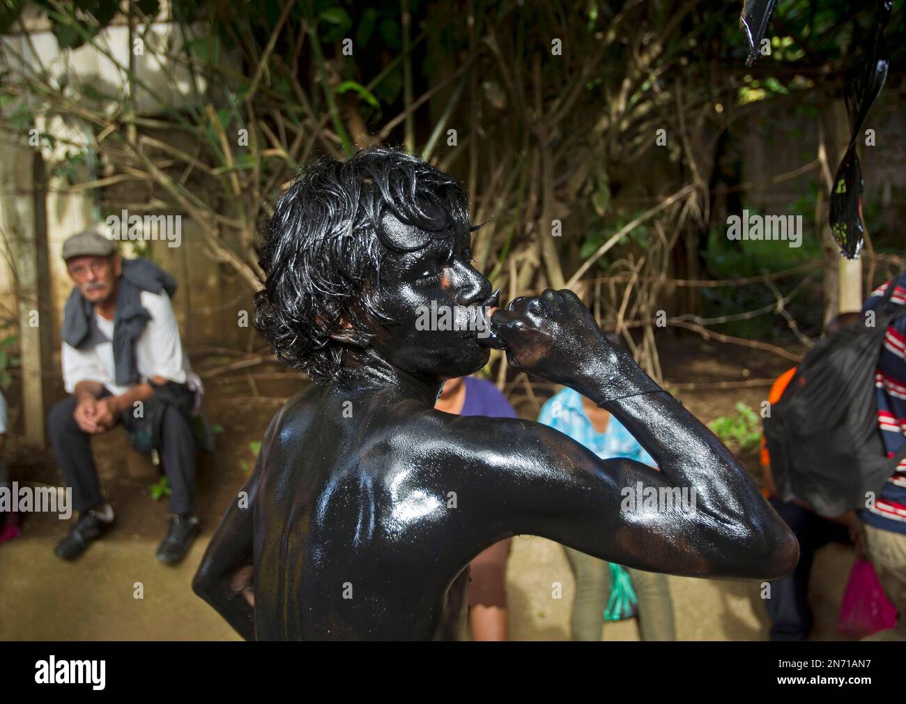 A youth with his body painted with recycled motor oil dances while ...