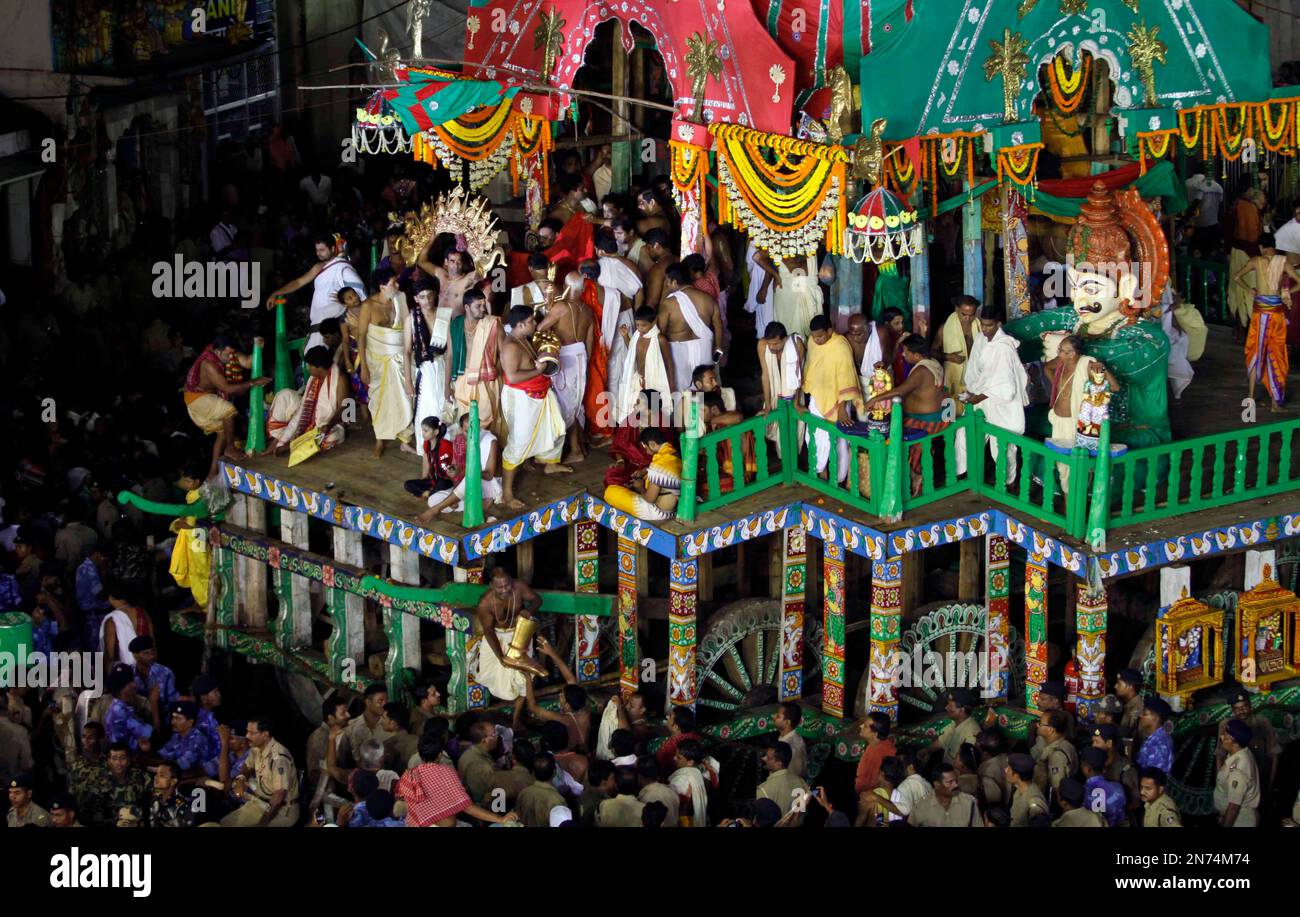 Temple workers carry golden ornaments on a decorated chariot during a ...