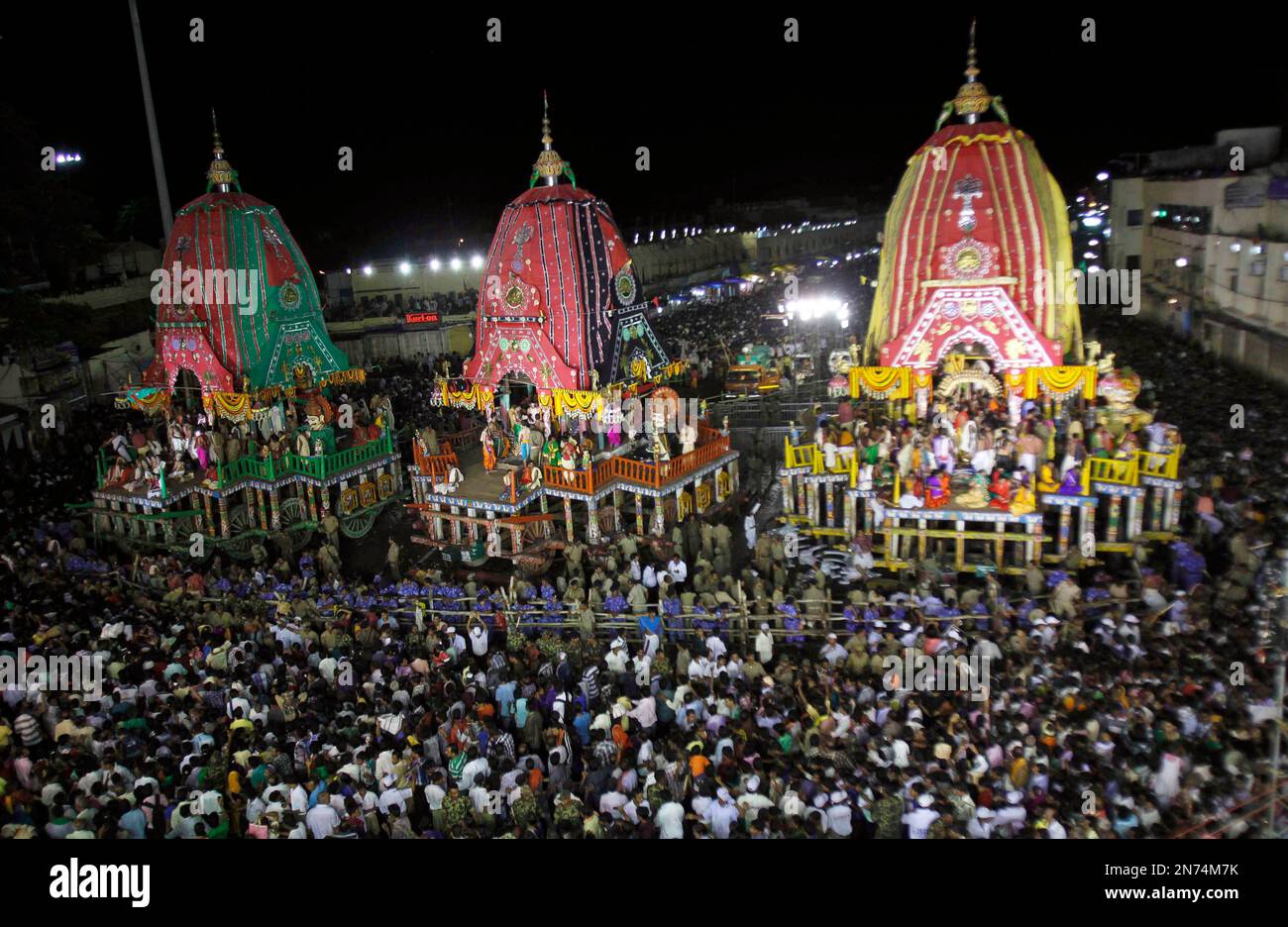 Devotees throng around decorated chariots outside the temple of ...