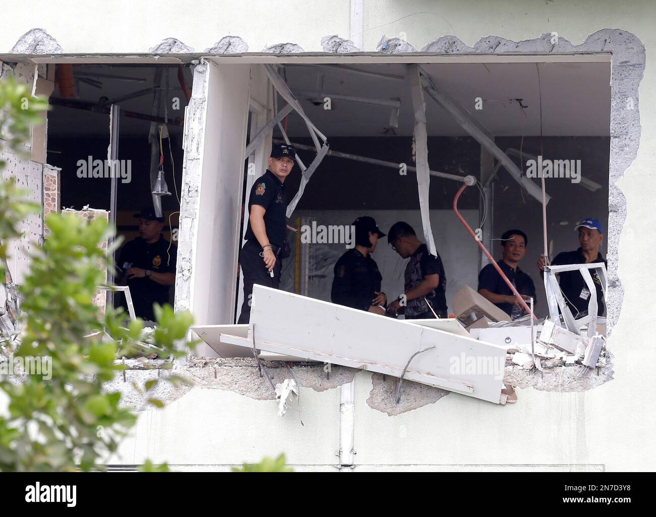 Philippine National Police investigators examine the scene of an ...