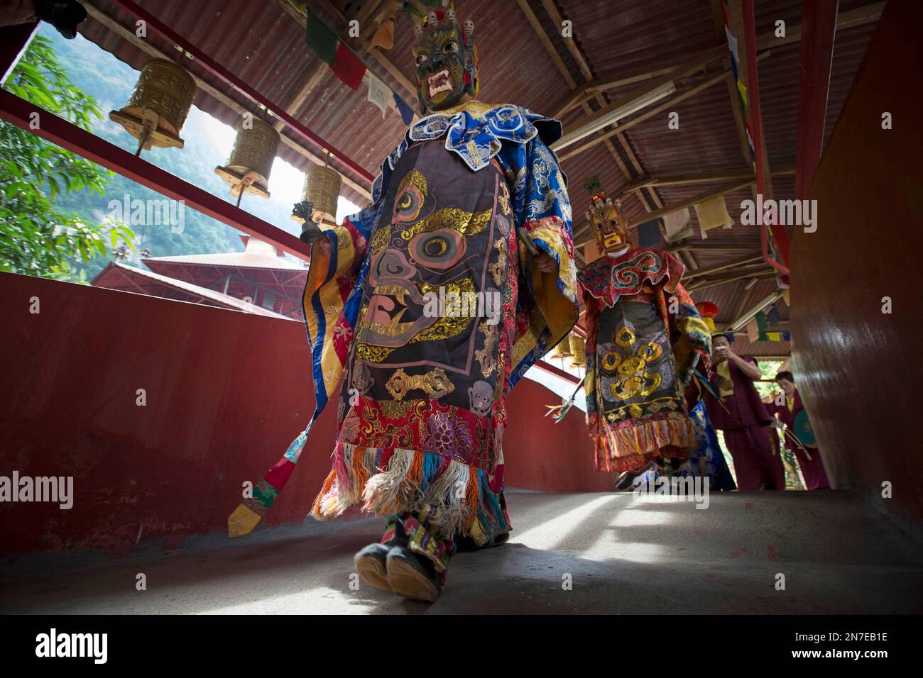 Monks wearing magnificent costumes and masks perform prayers before the ...