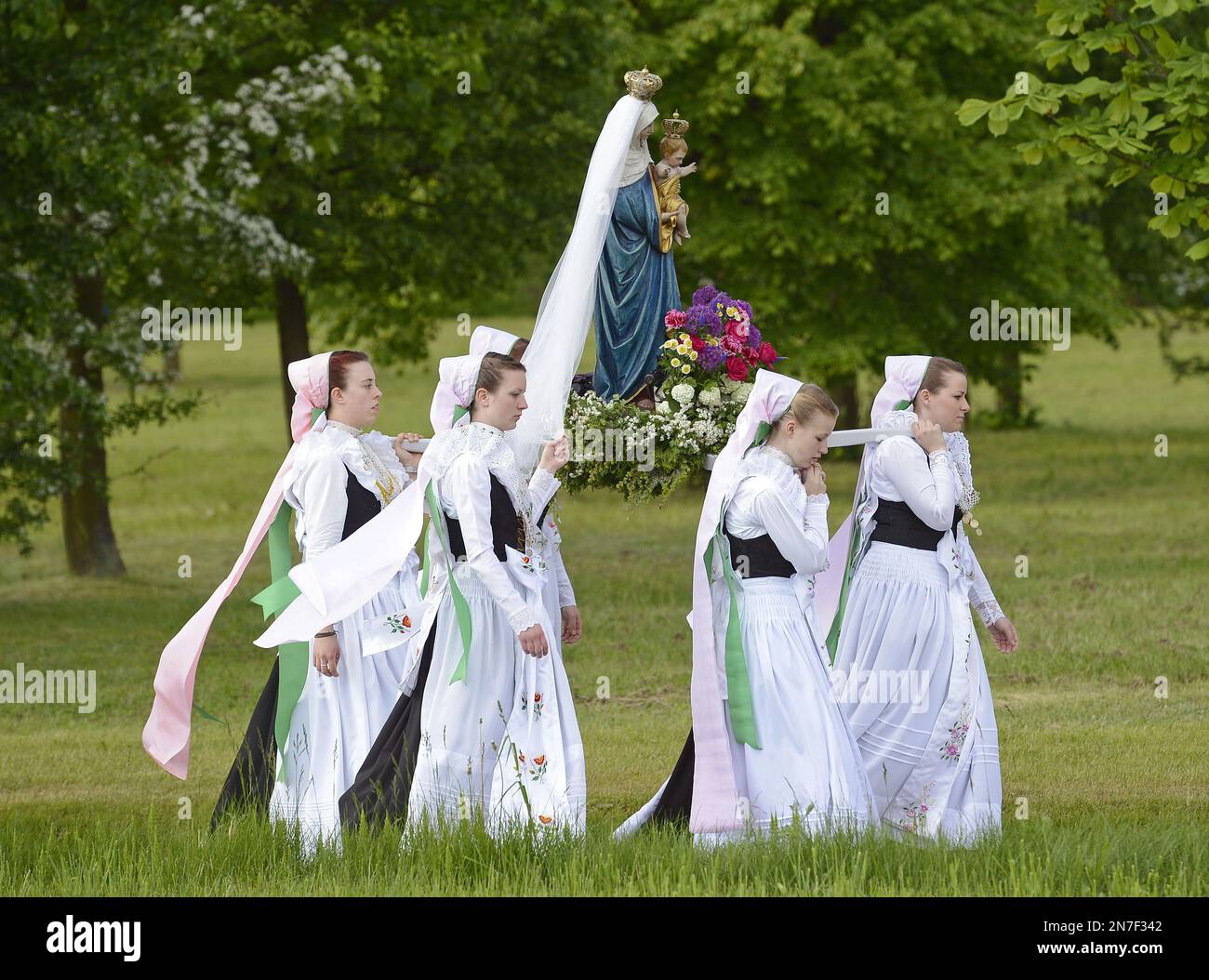 Women dressed in the traditional clothes of the Sorbs carry the statue ...