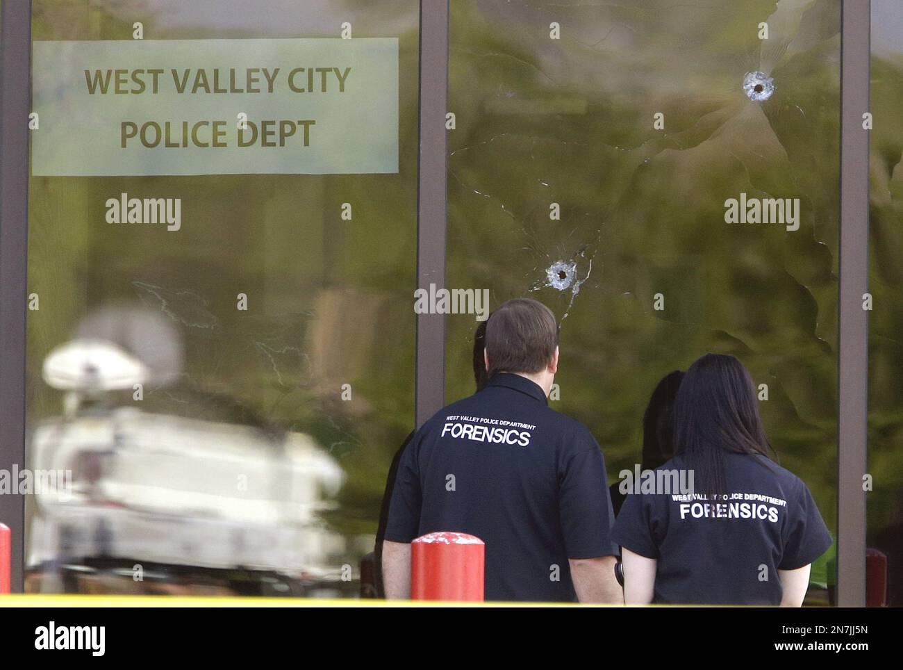 Members of the West Valley City Police Forensics Unit examine bullets ...