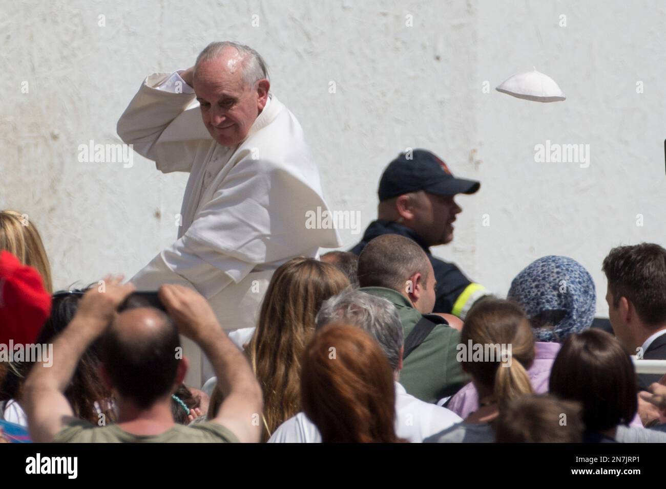 A gust of wind blows off Pope Francis's skull cap as he leaves St ...