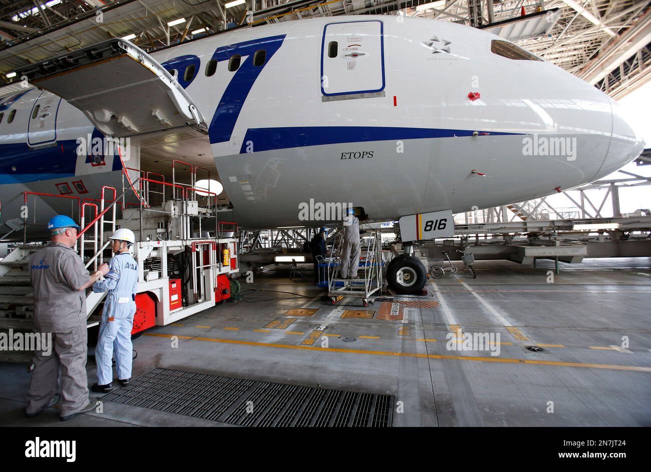 A member of Boeing Aircraft-on-Ground team works on the fuselage of an ...
