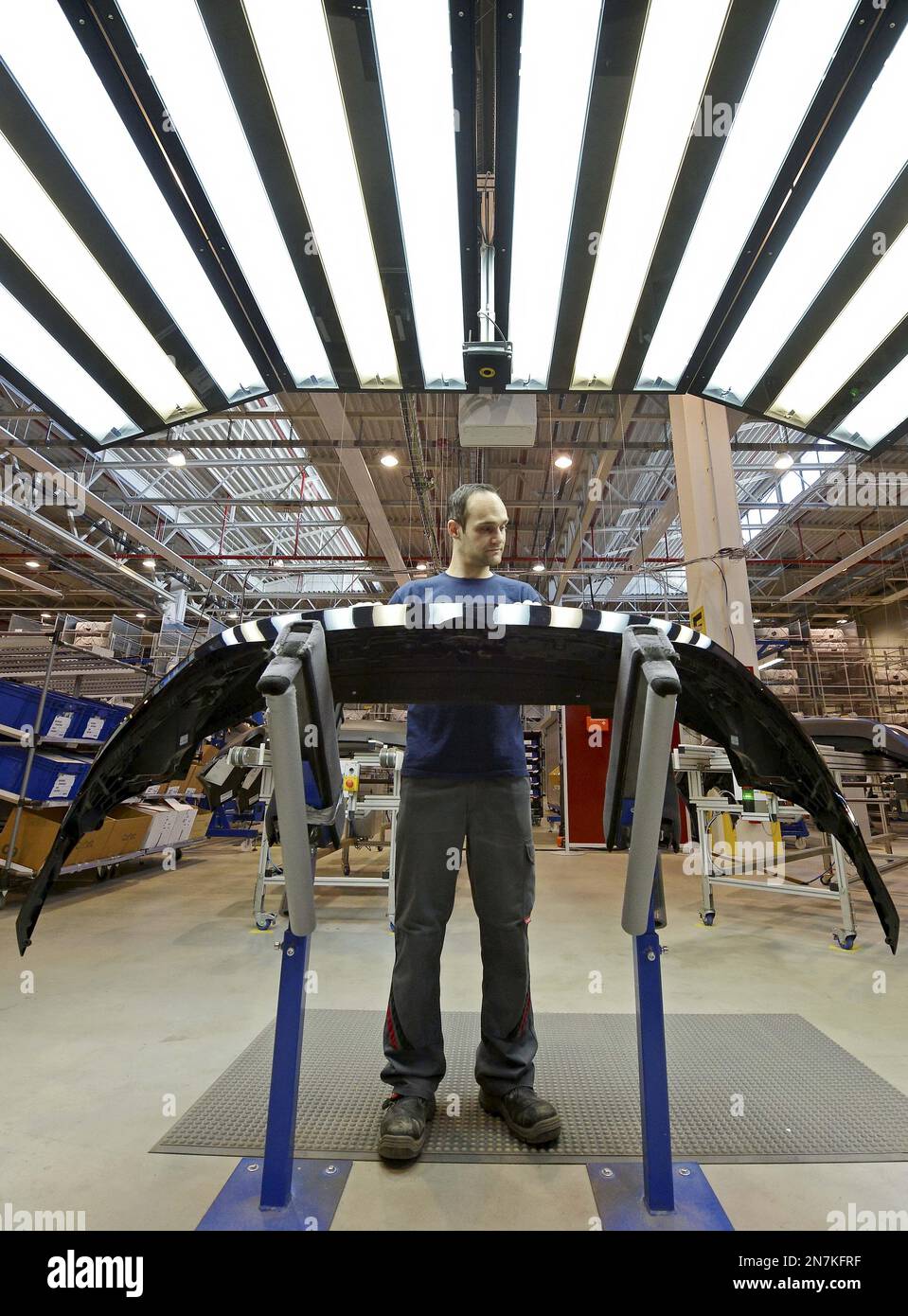 Assembler Christian Baumann transports a front car bumper during the ...
