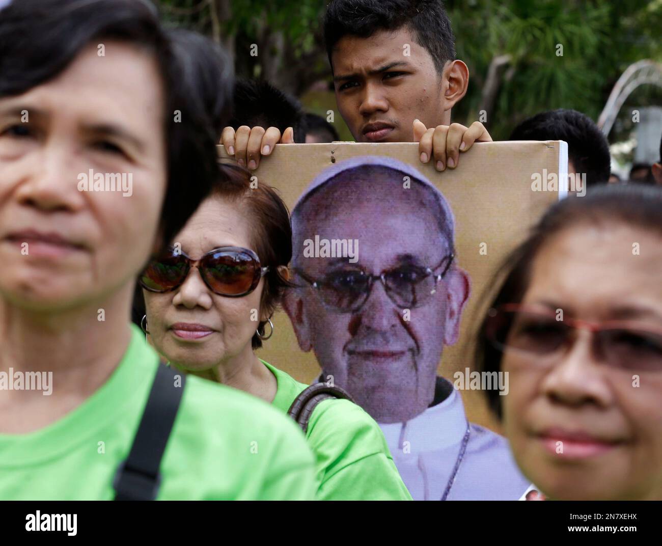 Filipino Catholic devotees display a portrait of new Pope Francis ...