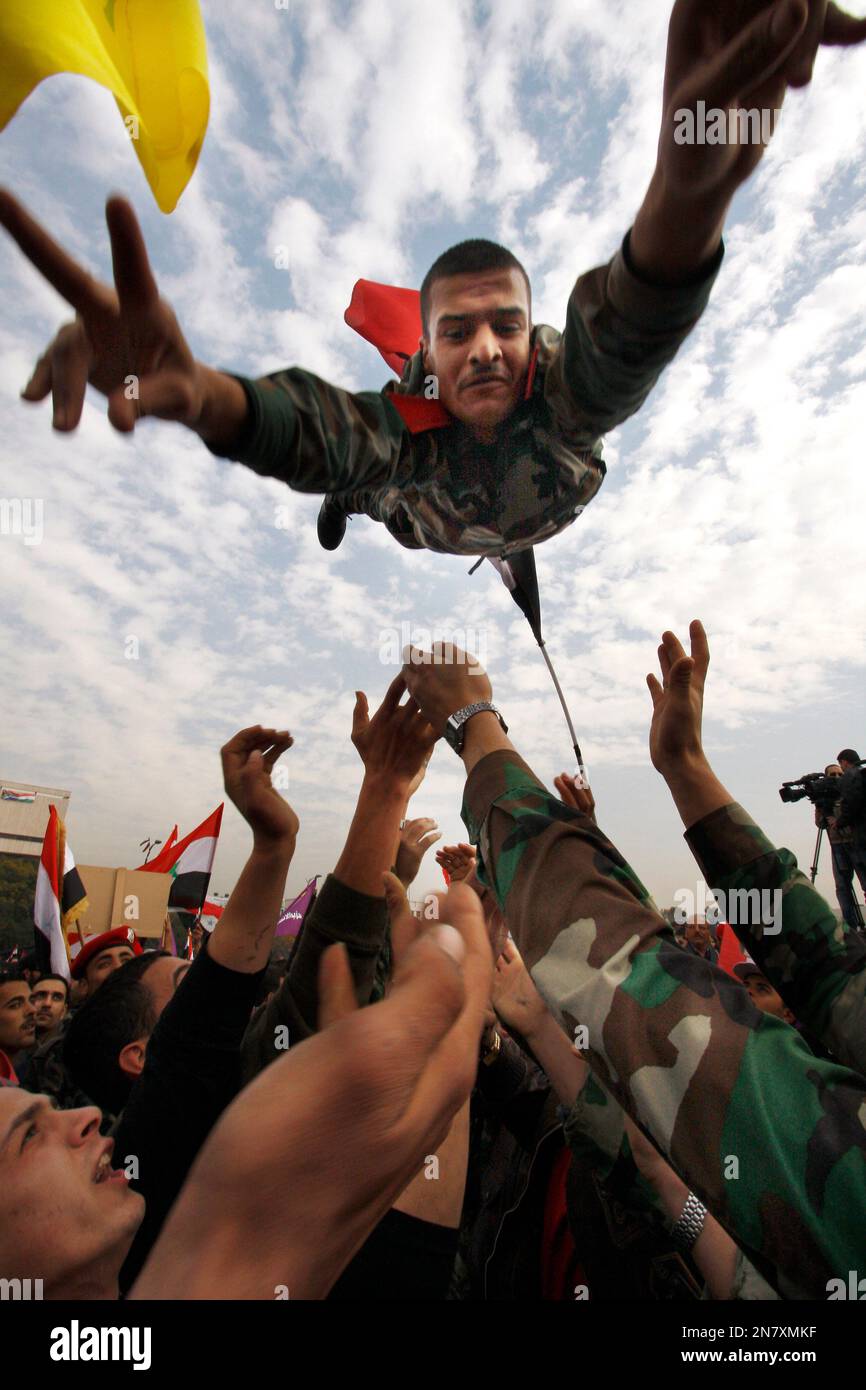 FILE - A Syrian solider flashes the victory sign as he is thrown in the ...