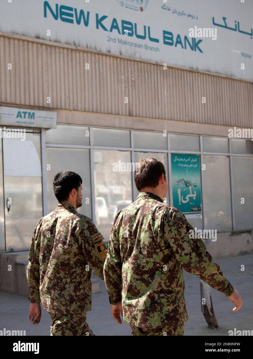 Afghan Army soldiers pass by a branch of the New Kabul Bank in the ...