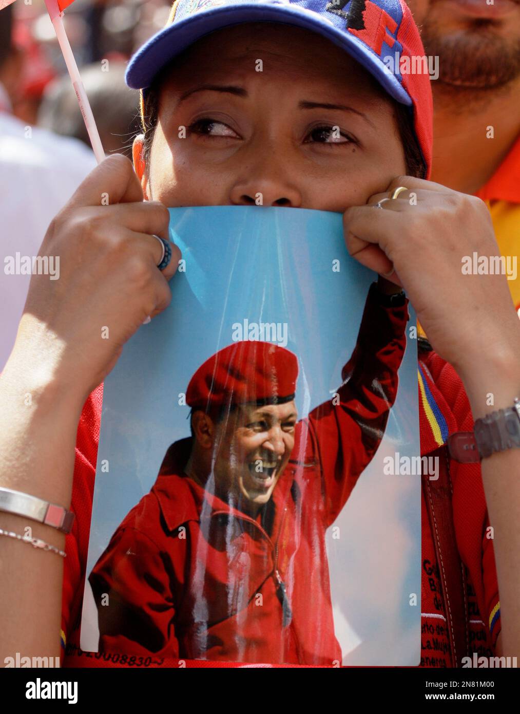 A woman holds a picture of Venezuela's President Hugo Chavez during an ...