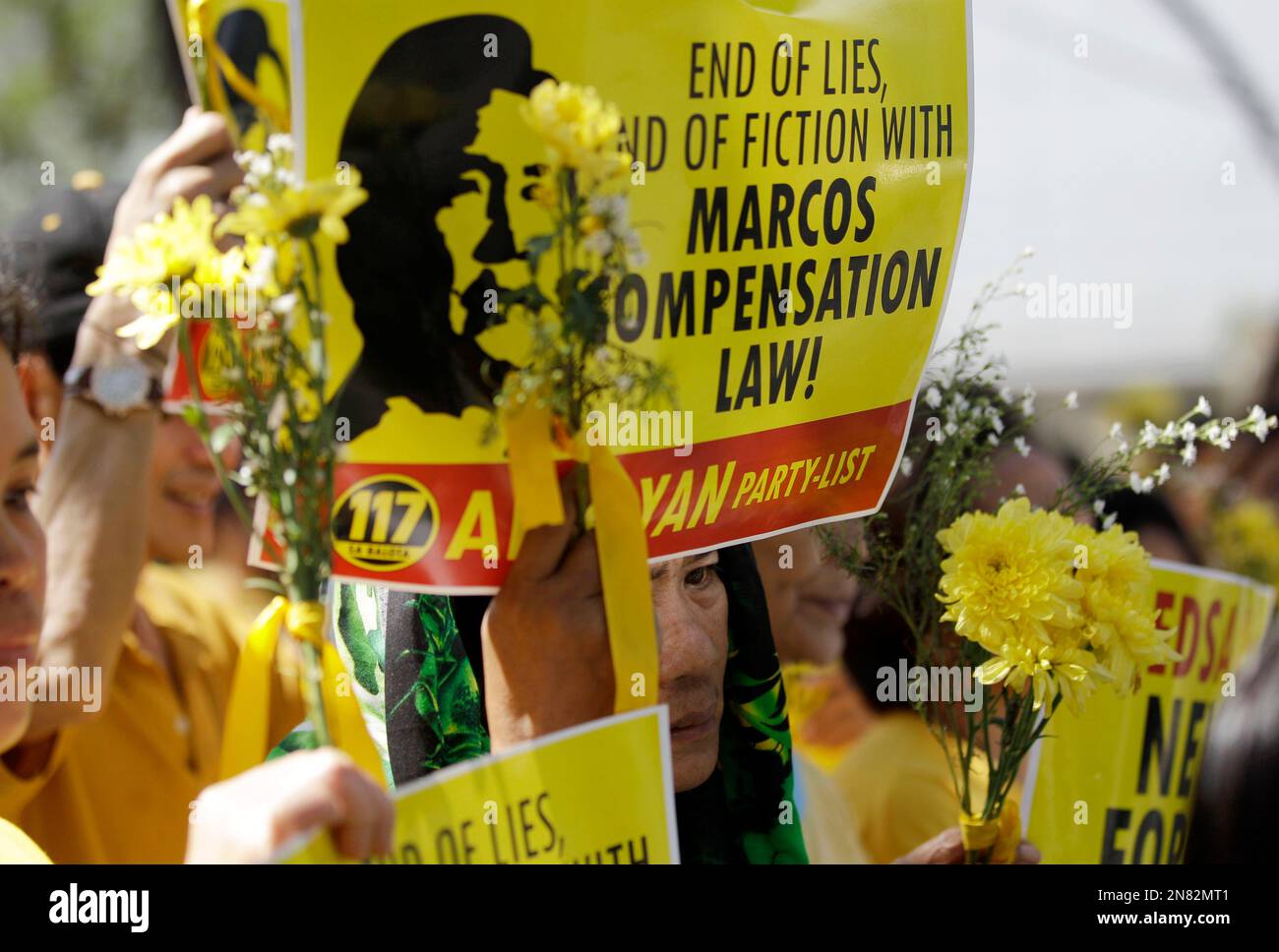 A Filipino activist holds slogans bearing an image of late Philippine ...