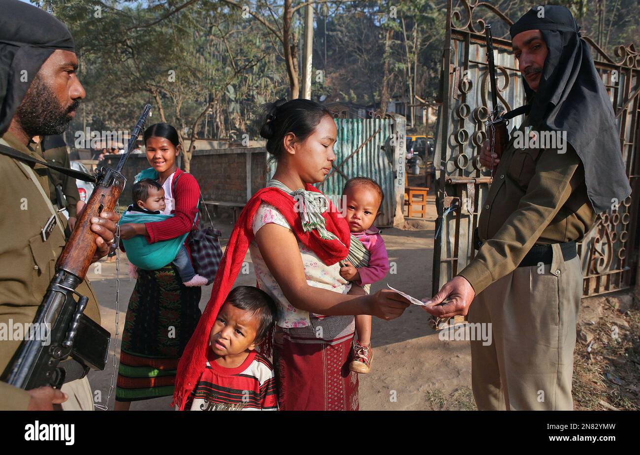 A security officer checks the identity card of a voter outside a ...