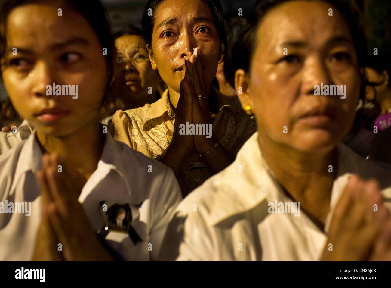 Cambodian mourners cry and pray outside a crematorium as the late King ...